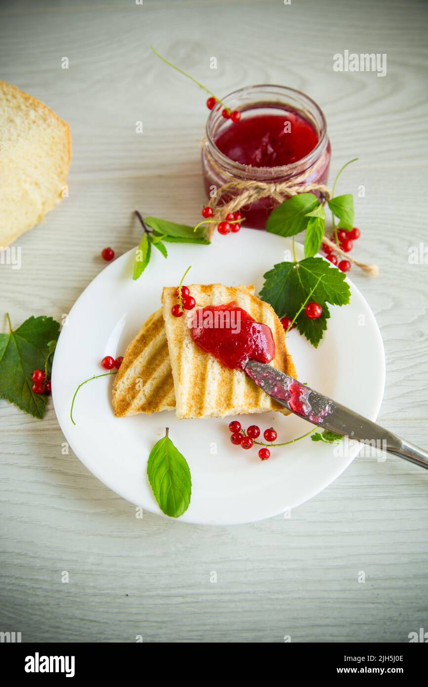fried bread croutons for breakfast with redcurrant jam in a plate with ...