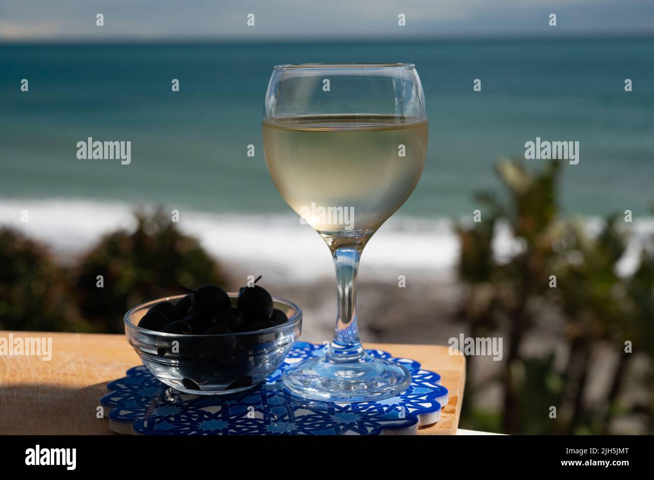 Spanish dry rueda white wine and black olives tapas served on beach ...