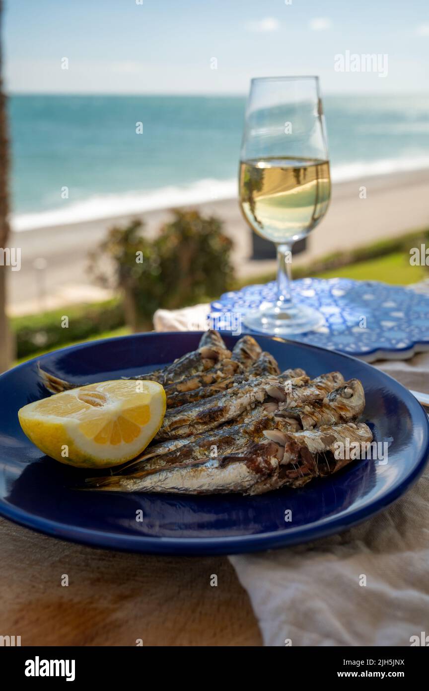 Sardines espeto prepared on skewers and open flame on fireplace with ...