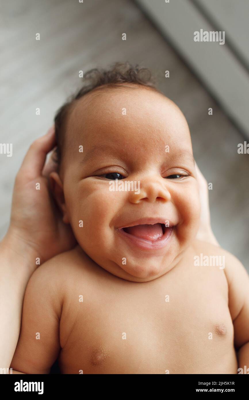 Laughing african baby on mom hands, free space Stock Photo - Alamy
