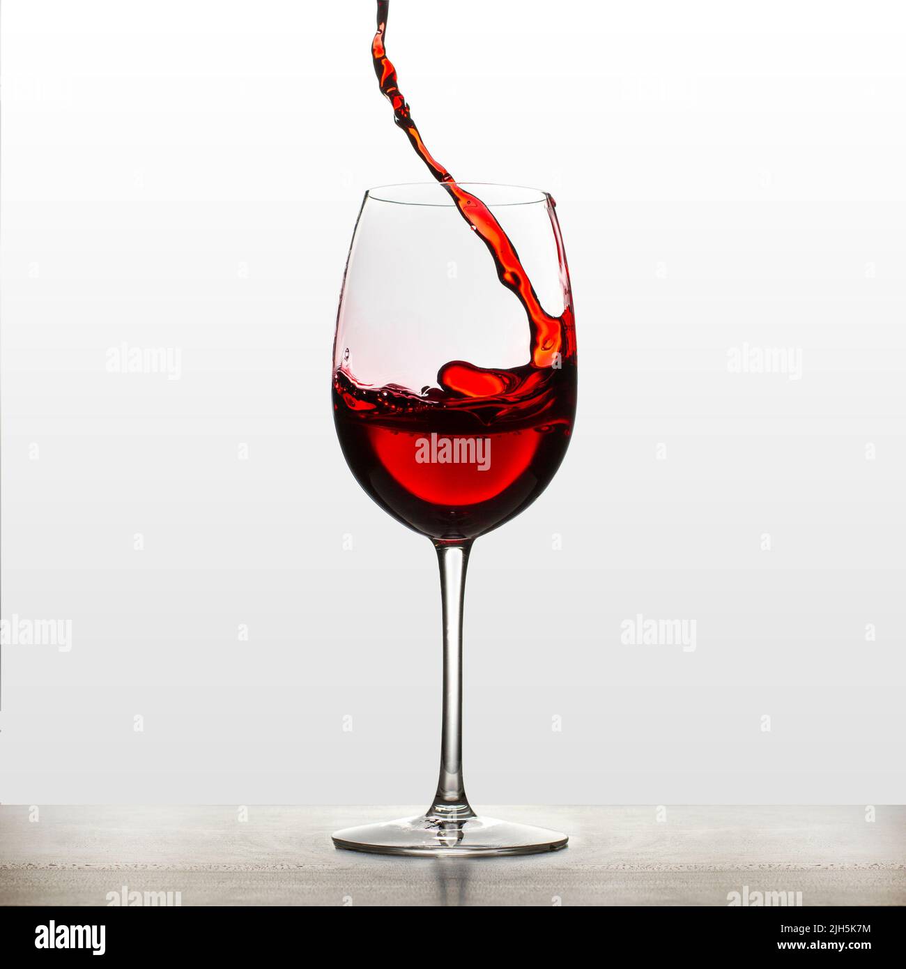 A splash of red wine in a glass for wine. Wine splashes. Drinking water ...