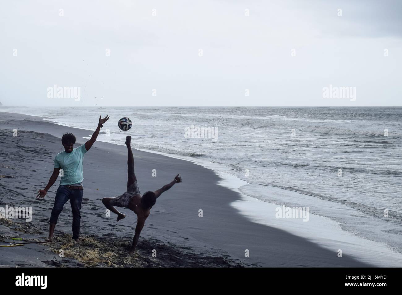 people playing football at beach in the evening Stock Photo - Alamy