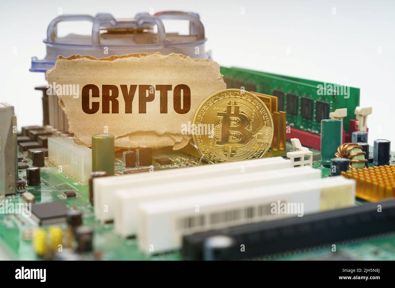 Crypto - business concept. On the motherboard lies a bitcoin coin and a ...