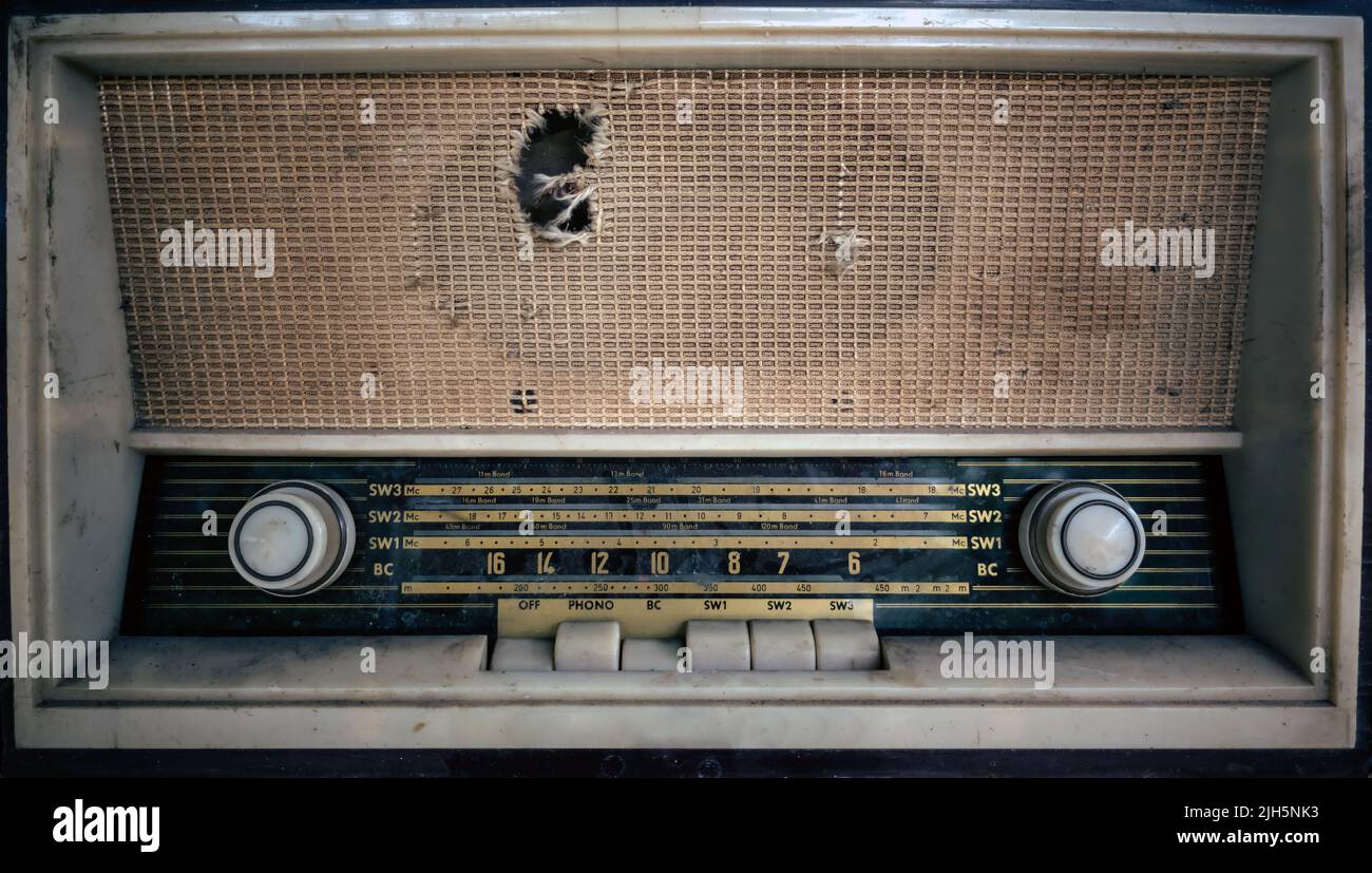 Front view of ancient radio receiver has deteriorated over time. Retro ...