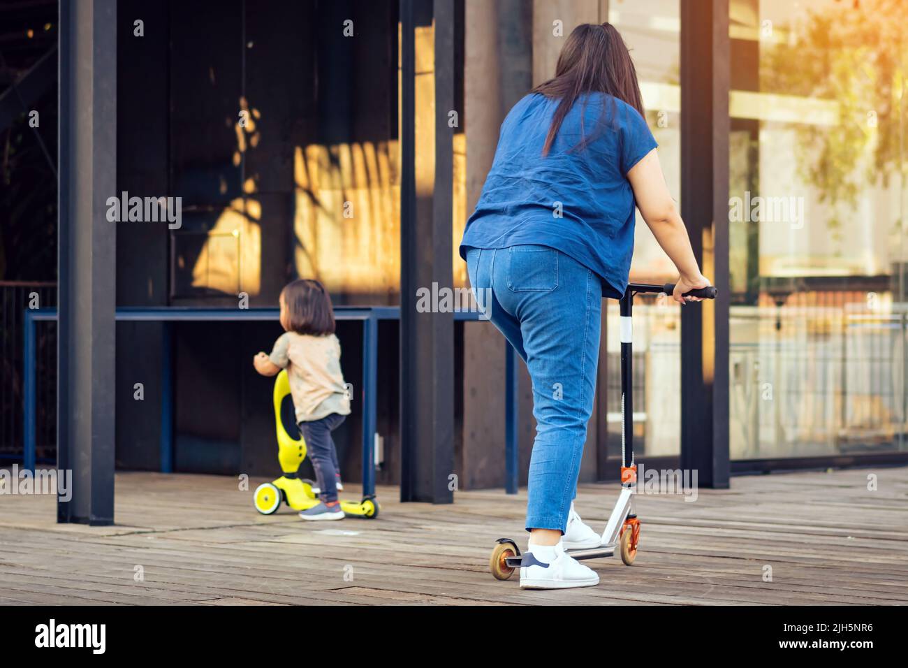 Asian woman enjoy playing and riding modern extreme stunt kick scooter ...