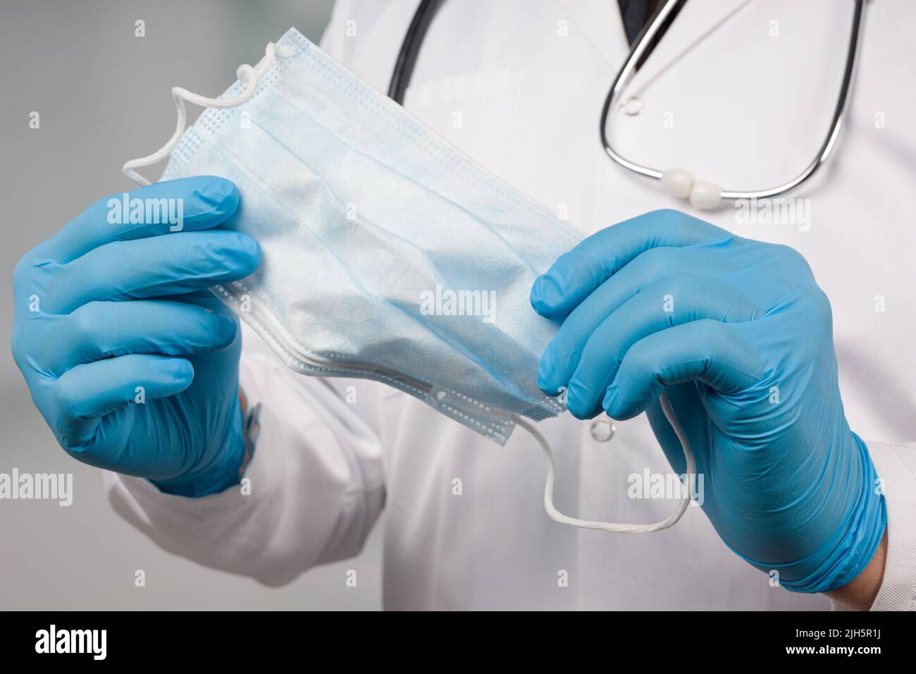 close up of doctor's hand with a medical face mask for protection ...
