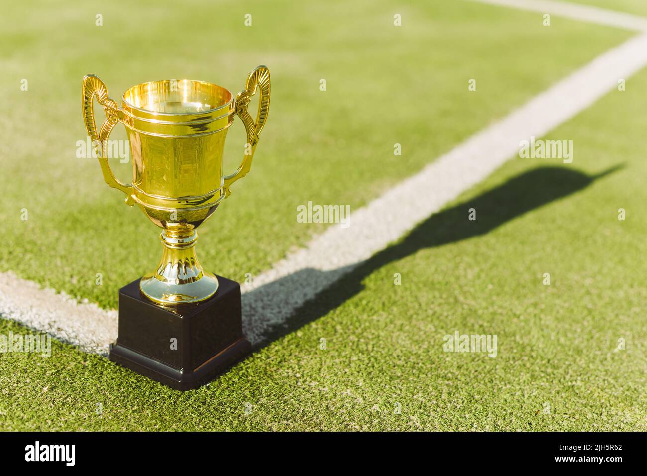 Golden prize cup for winner of competition on tennis court lawn Stock ...