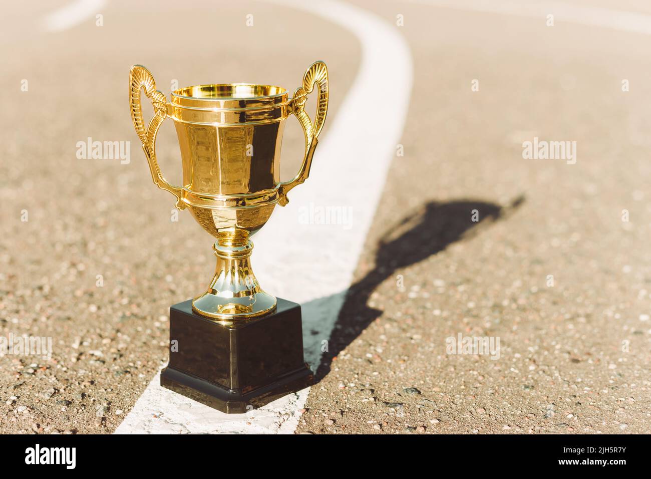 Gold prize cup for the winner of competition at athletics stadium Stock ...