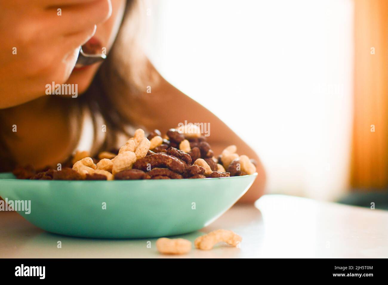 Close up view caucasian boy sit to eat cereals in kitchen on white ...