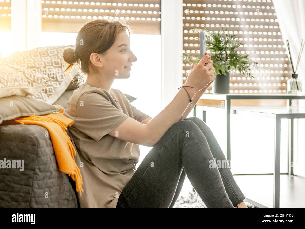 Beautiful girl using smartphone home hi-res stock photography and ...