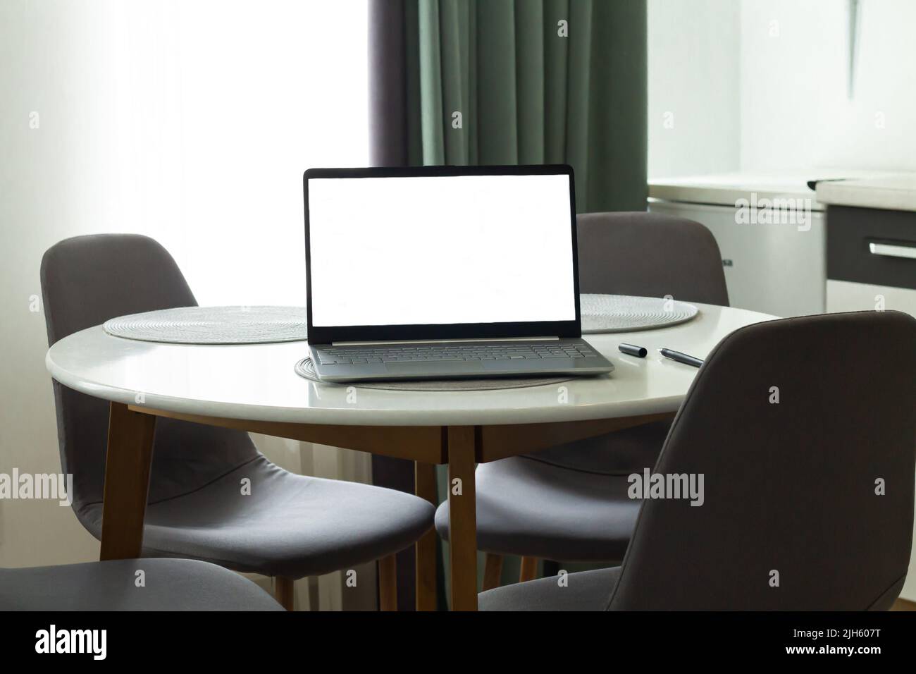 Open laptop computer with blank white monitor screen mockup on round ...