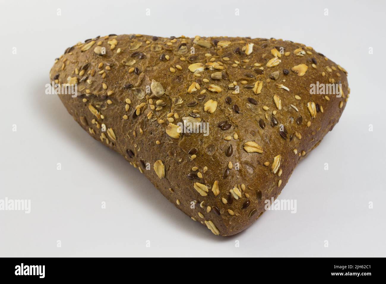 A bun in the form of a triangle sprinkled with sunflower seeds and ...