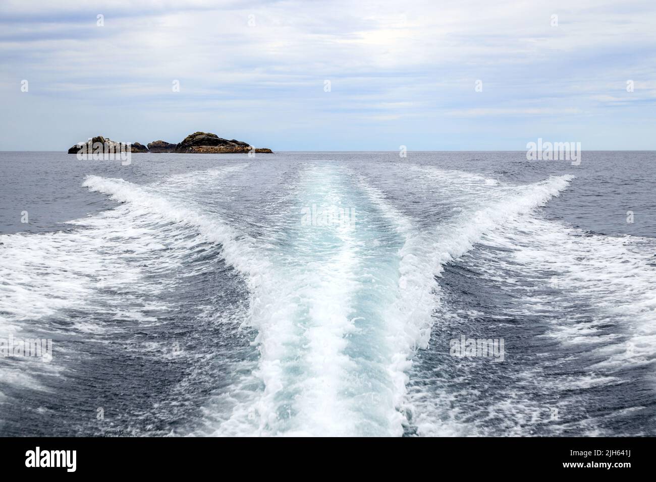 An outboard motor wake from a cruising powerboat on the sea in a ...