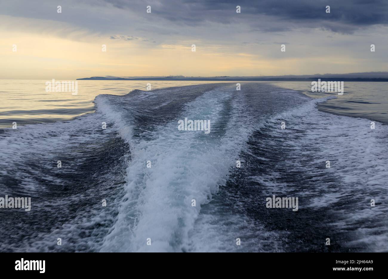 An outboard motor wake from a cruising powerboat on the sea in a ...
