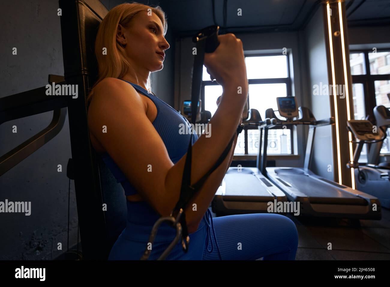 Female athlete doing resistance training in fitness studio Stock Photo ...