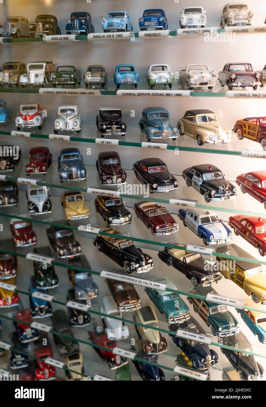 Extensive collection of vintage die-cast model cars displayed on glass ...