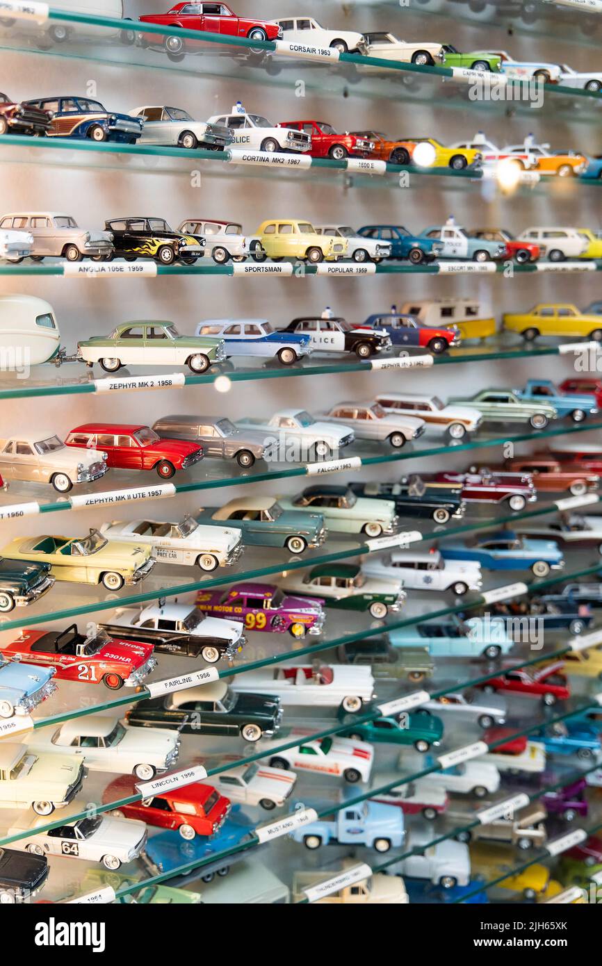 Collection of vintage model cars displayed on glass shelves in museum ...