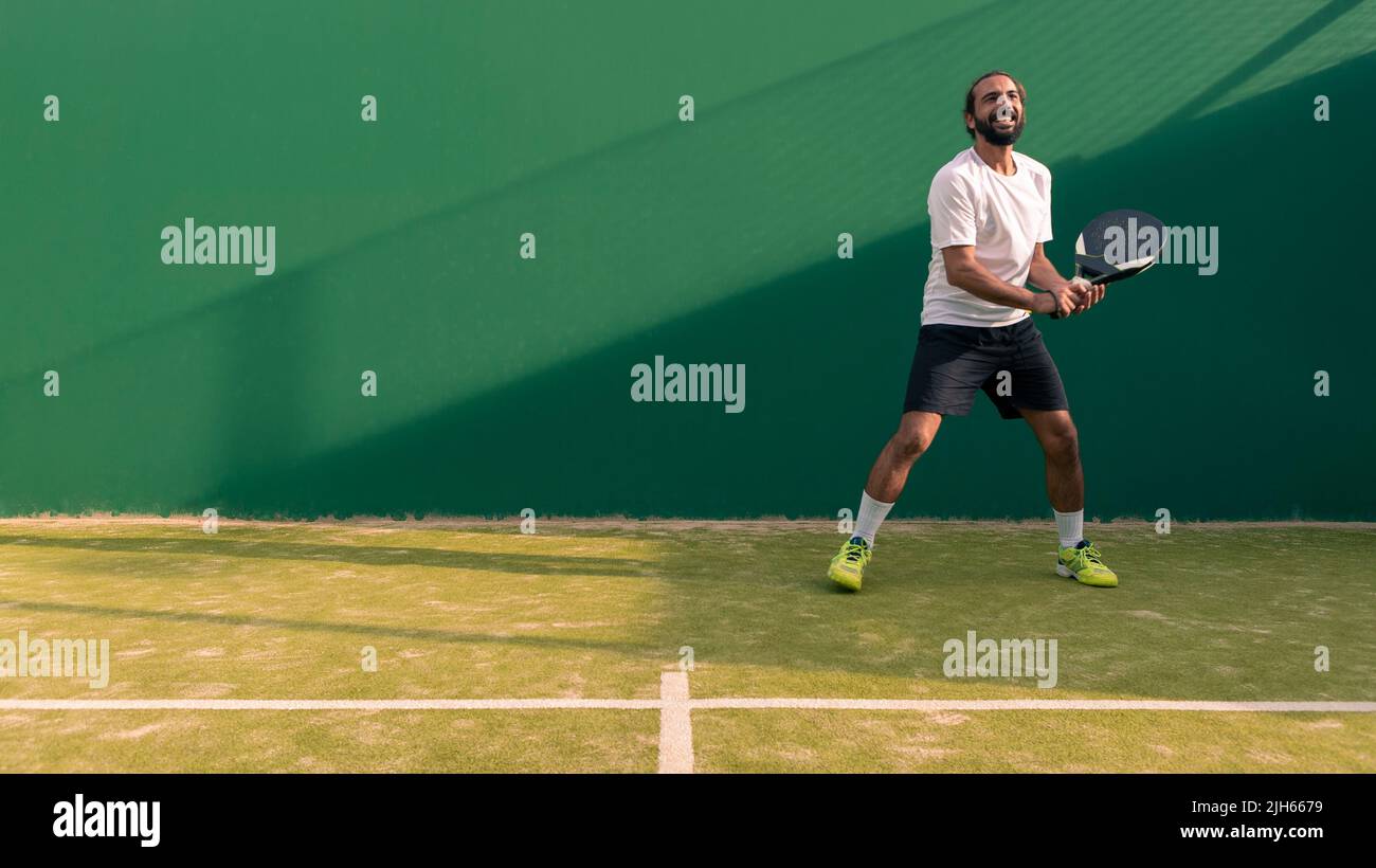 A caucasian padel player jump to the ball, good looking for posts and ...