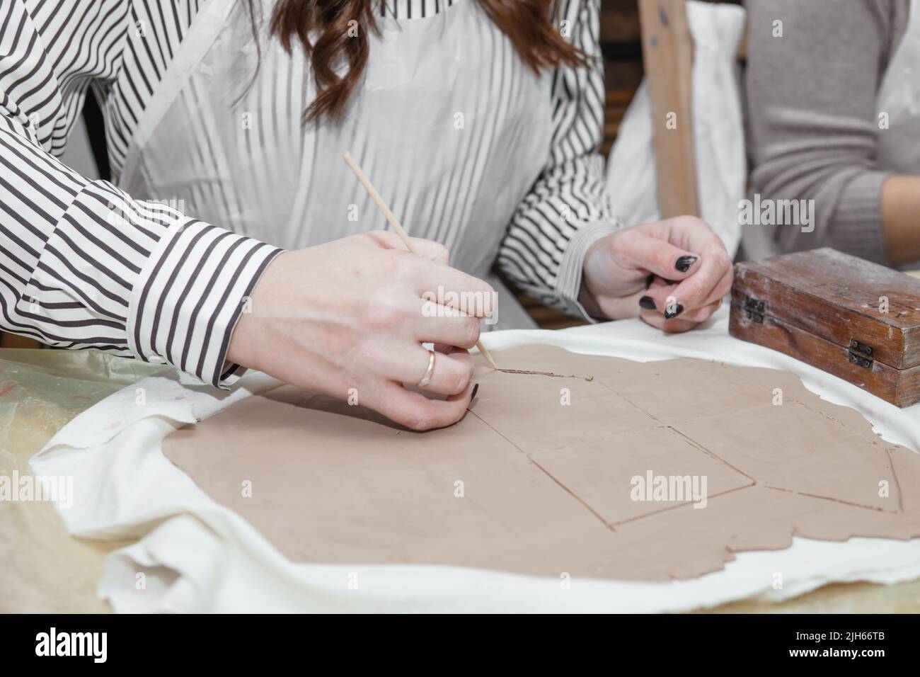 Women's hands knead clay, drawing elements of the product. Production ...