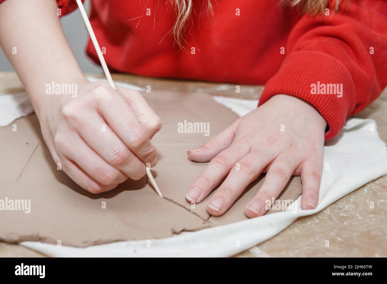 Women's hands knead clay, drawing elements of the product. Production ...