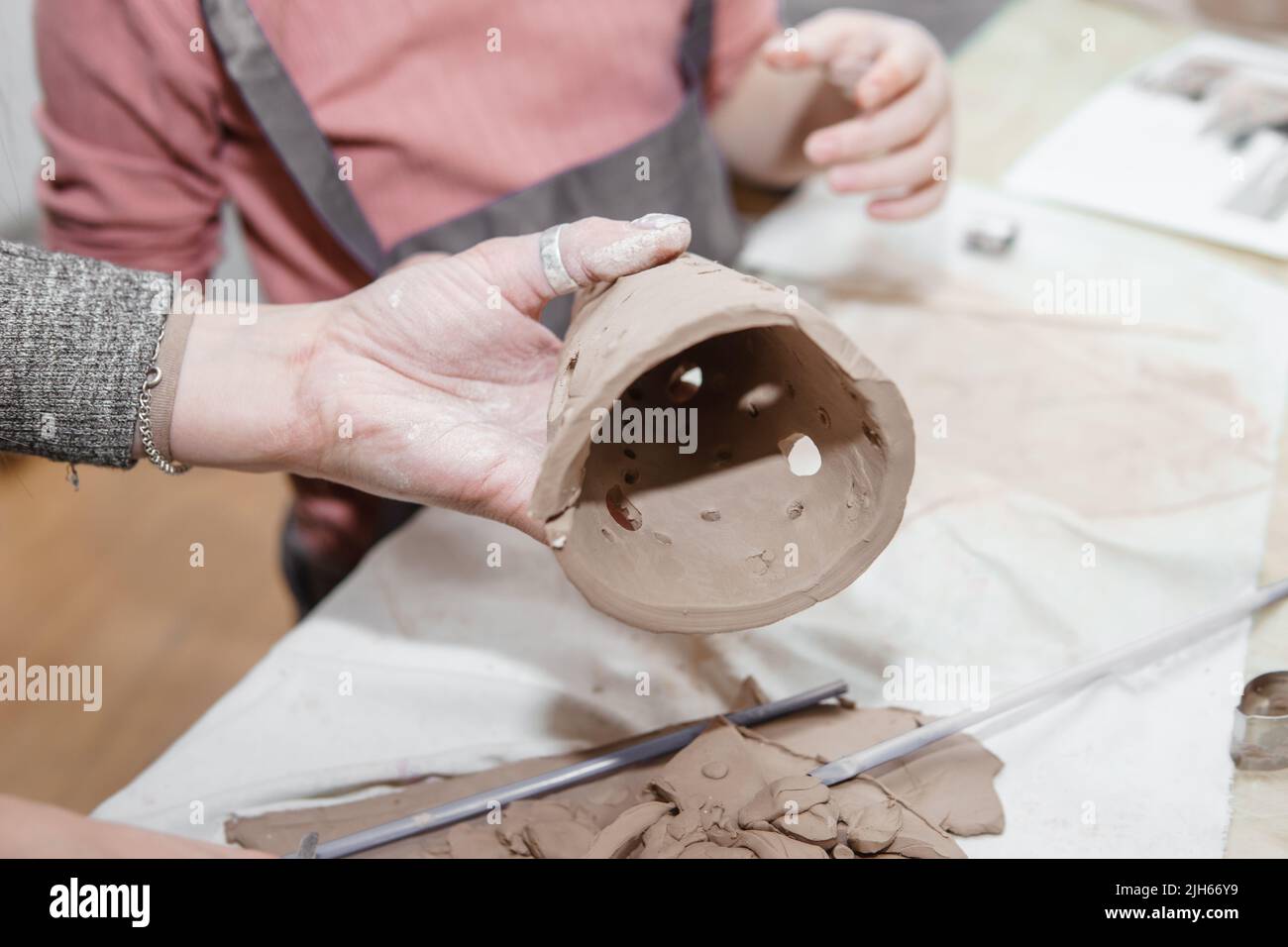 Women's hands knead clay, drawing elements of the product. Production ...