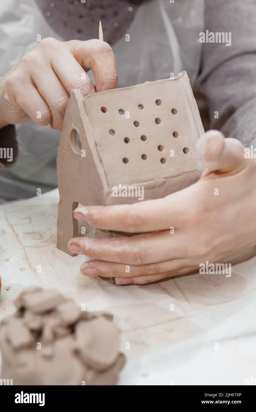 Women's hands knead clay, drawing elements of the product. Production ...