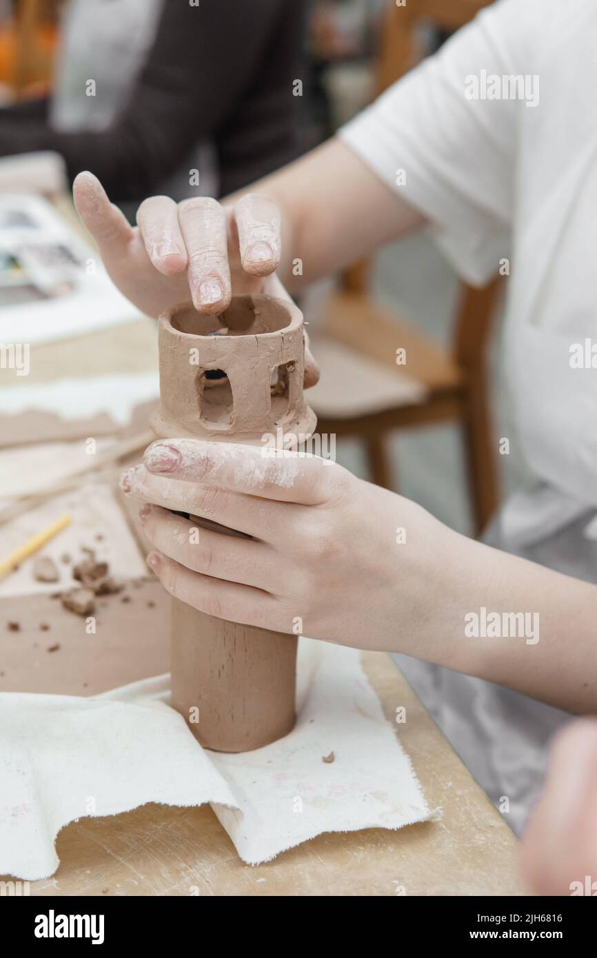 Women's hands knead clay, drawing elements of the product. Production ...
