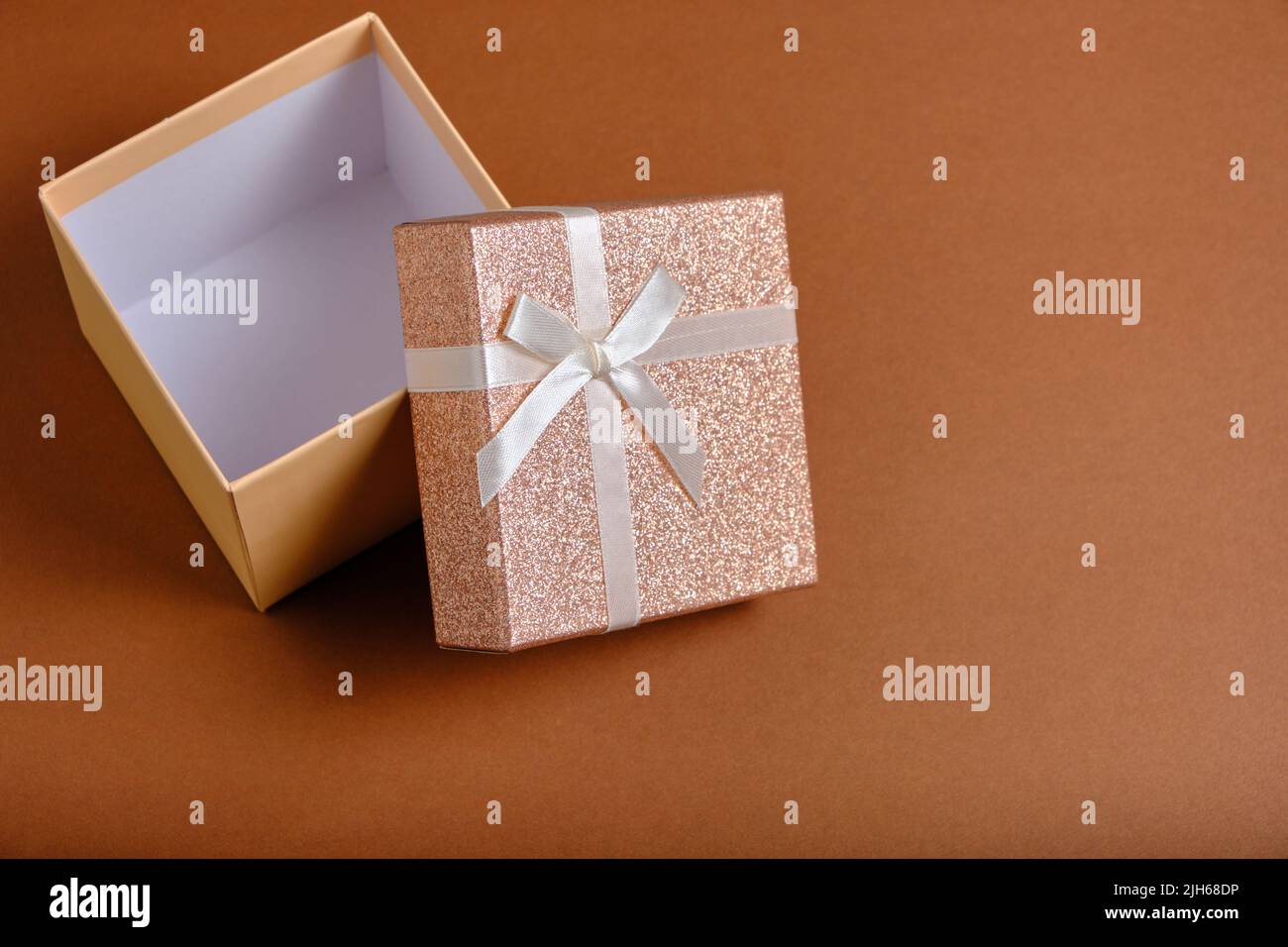 Open gift box brown background is tied with beige ribbon with bow Stock ...