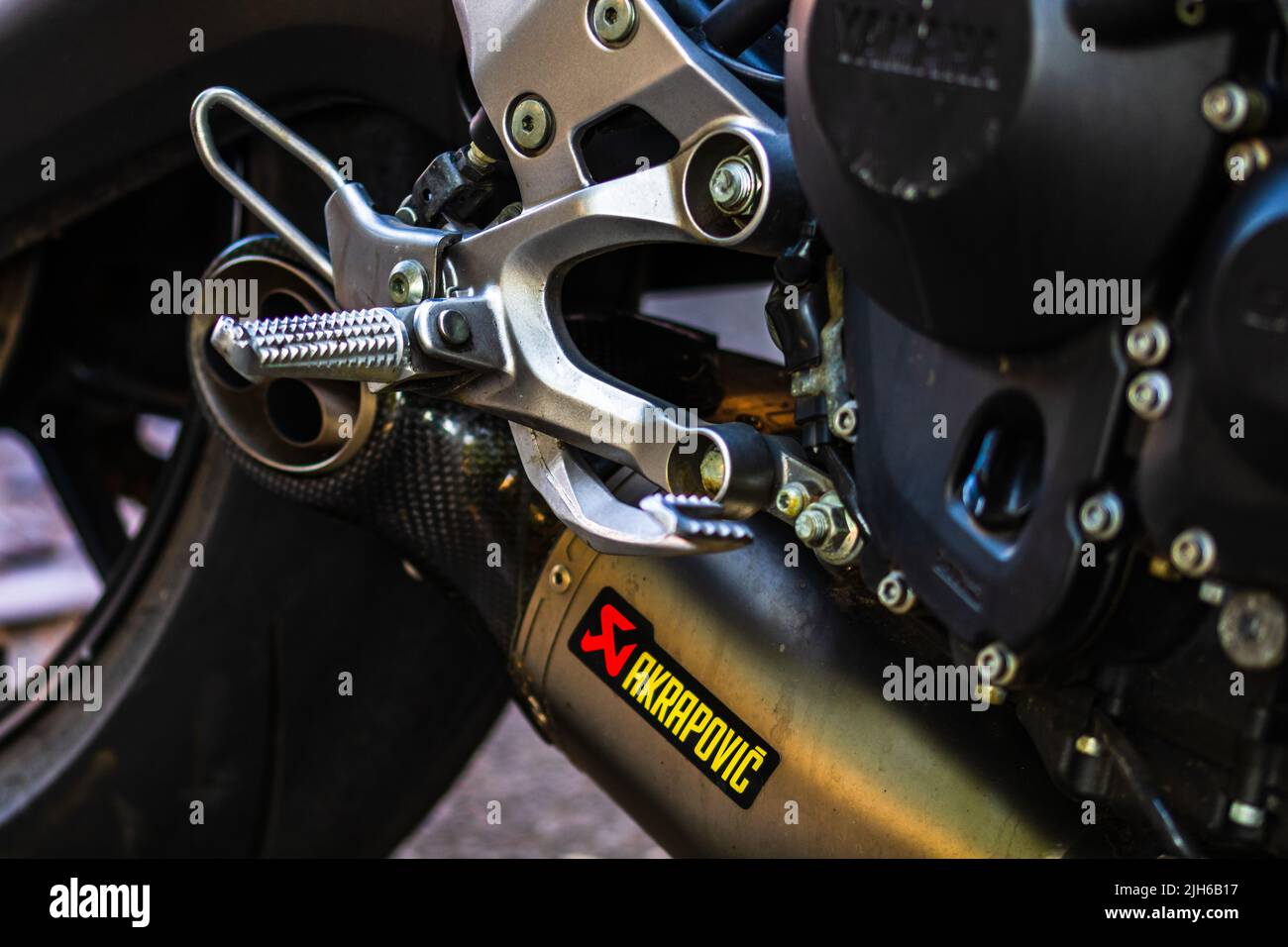 A close-up photo of Akrapovic exhaust muffler on custom motorcycle in ...