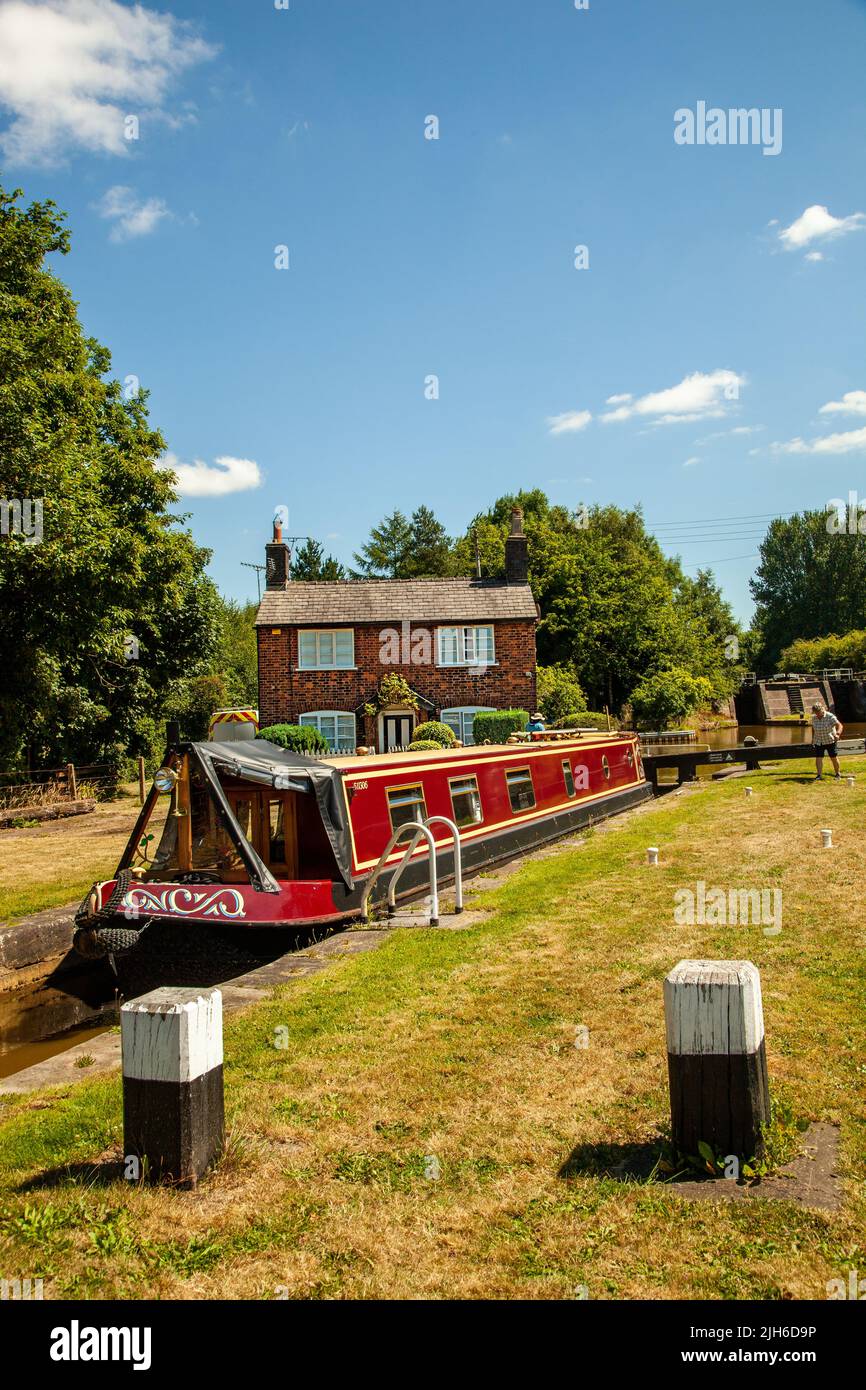 Canal narrowboat passing through locks on the Trent and Mersey canal as ...