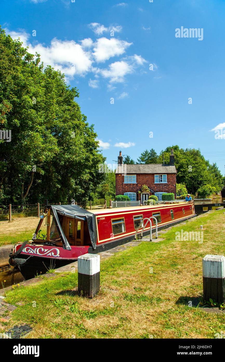 Canal narrowboat passing through locks on the Trent and Mersey canal as ...