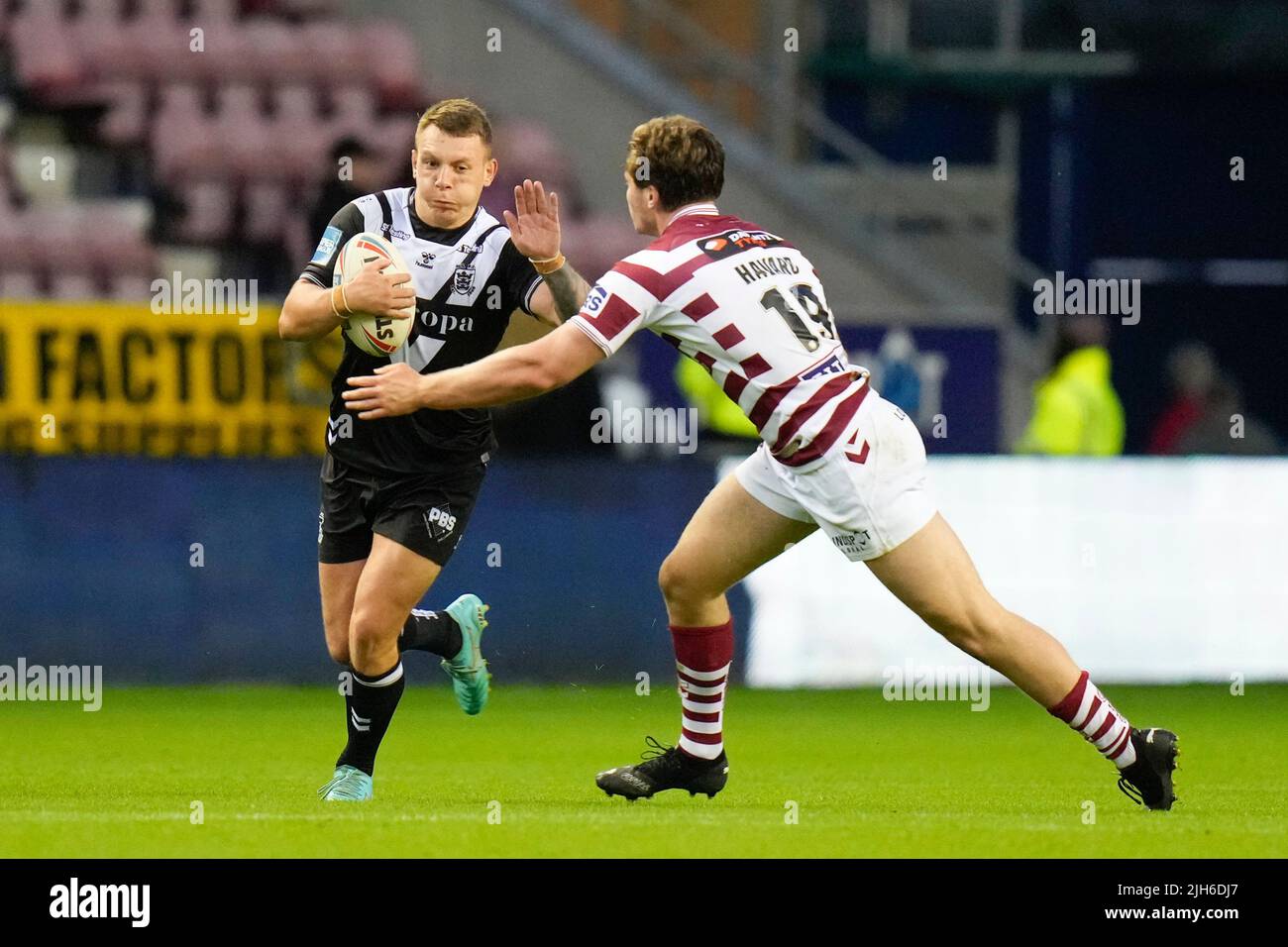 Jordan Lane #13 of Hull FC runs at Ethan Havard #19 of Wigan Warriors ...