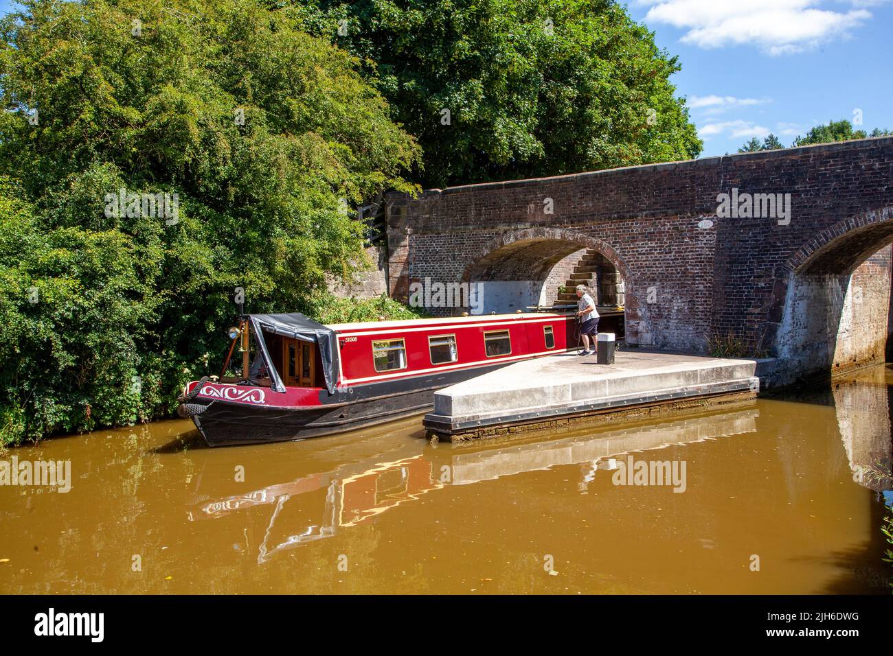 Canal narrowboat passing through locks on the Trent and Mersey canal as ...