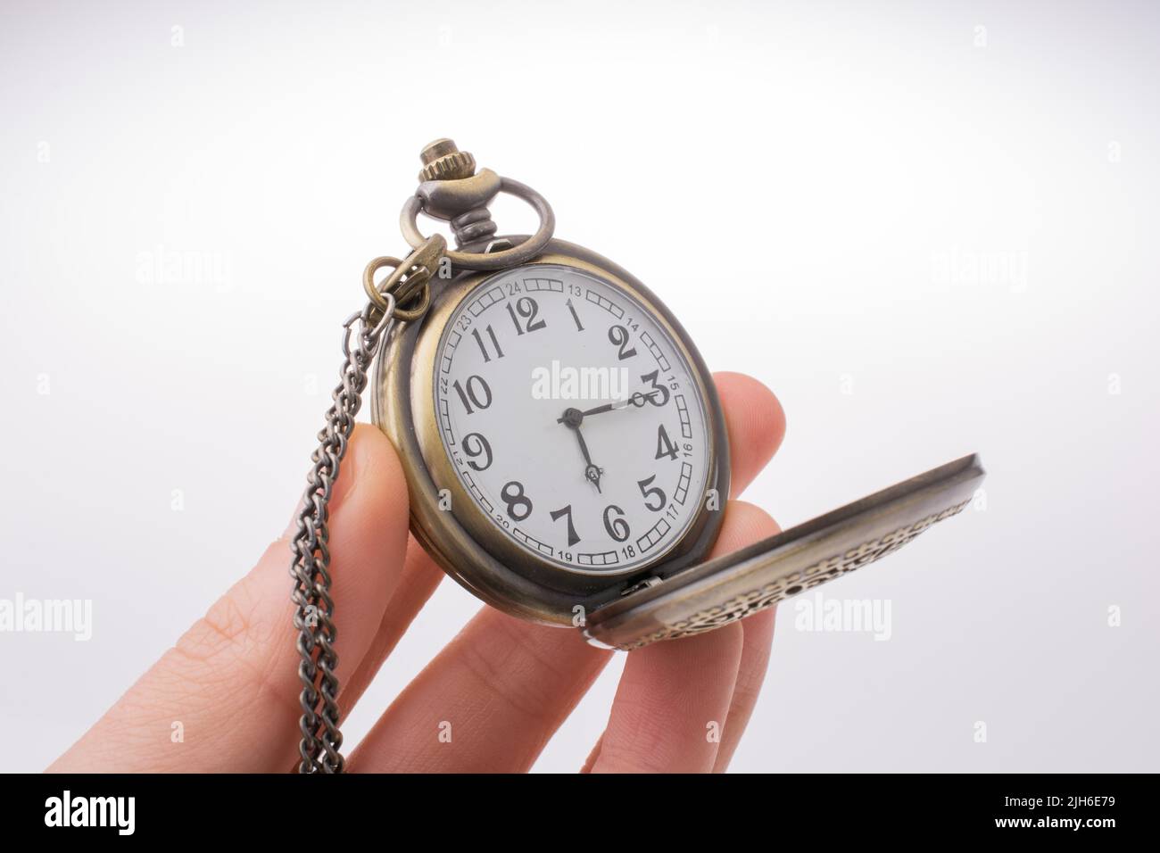 Retro style pocket watch in hand on white background Stock Photo - Alamy