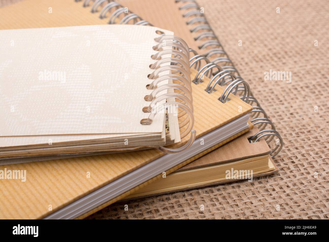 Brown color spiral notebook placed on a canvas background Stock Photo ...