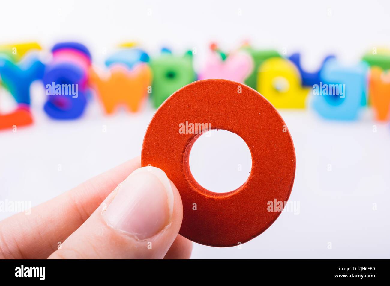 Hand holding letter cube O of made of wood Stock Photo - Alamy