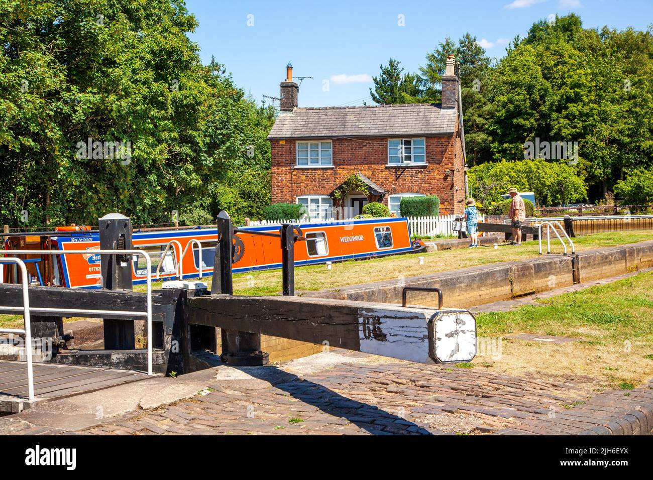 Canal narrowboat passing through locks on the Trent and Mersey canal as ...