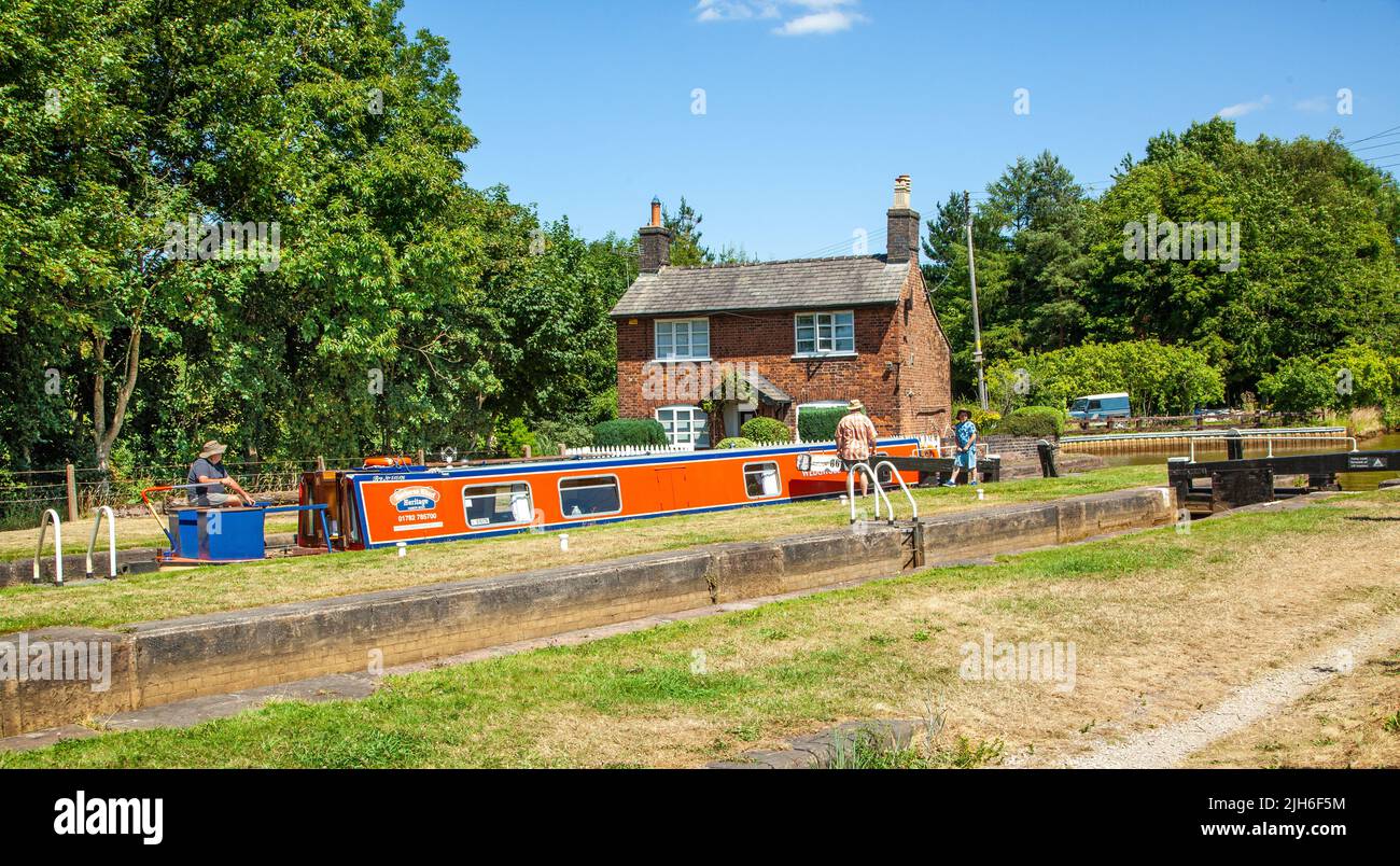 Canal narrowboat passing through locks on the Trent and Mersey canal as ...