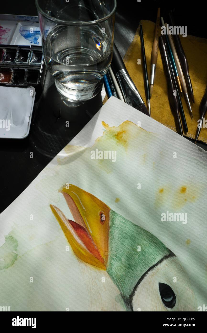 Painted goose, watercolour painting with water glass, brushes and ...