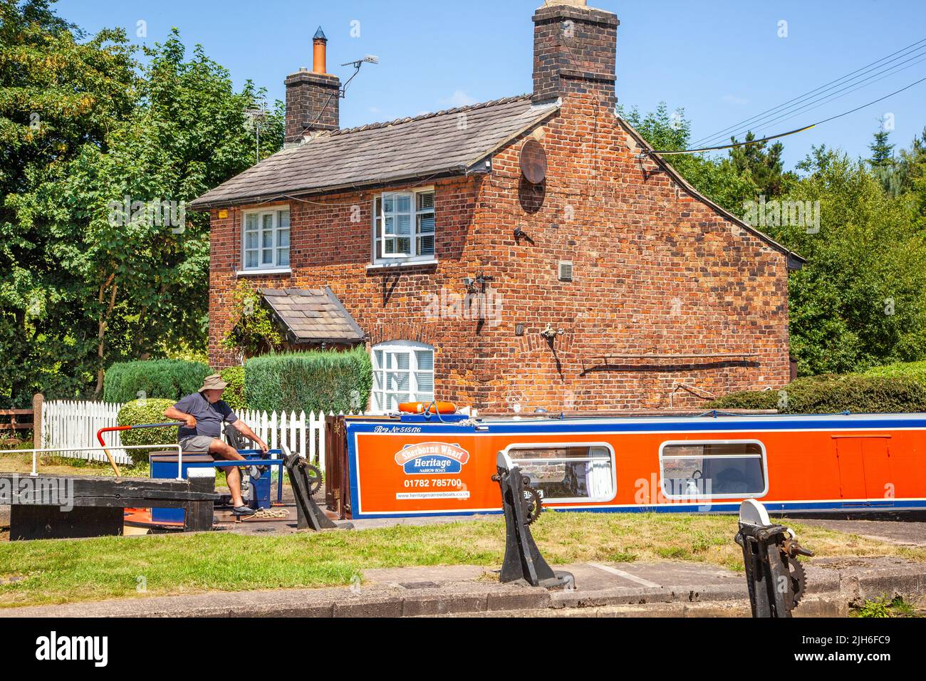 Canal narrowboat passing through locks on the Trent and Mersey canal as ...