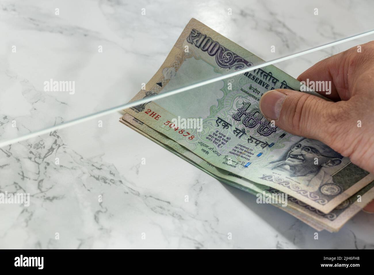 Indian money clip, 100 rupee banknotes, Passing through a bank window ...