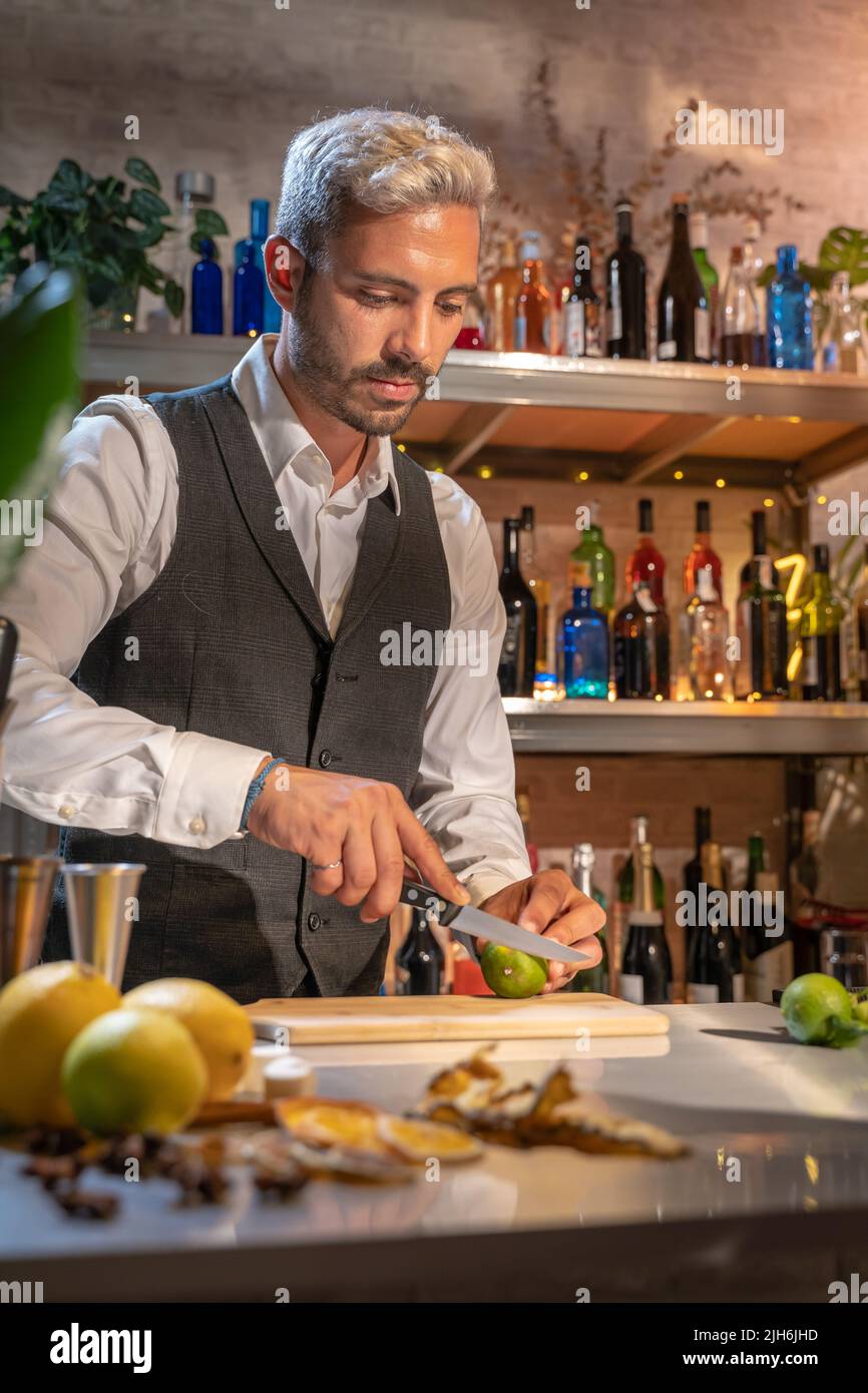 Barman making cocktail Mojito in night club adding ingredients and ...
