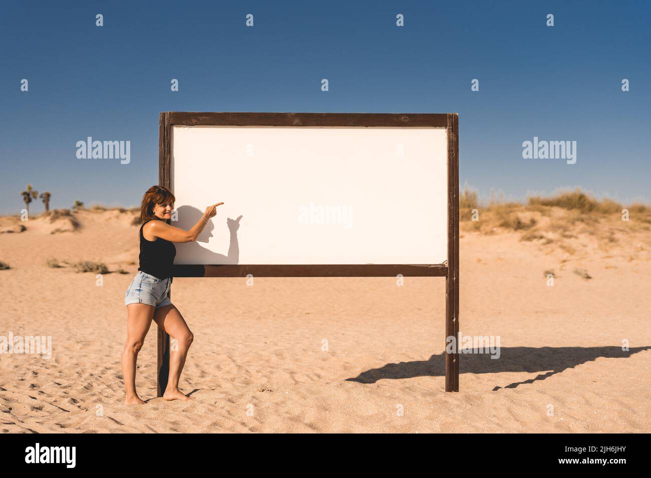 woman pointing to a sign on the beach Stock Photo - Alamy