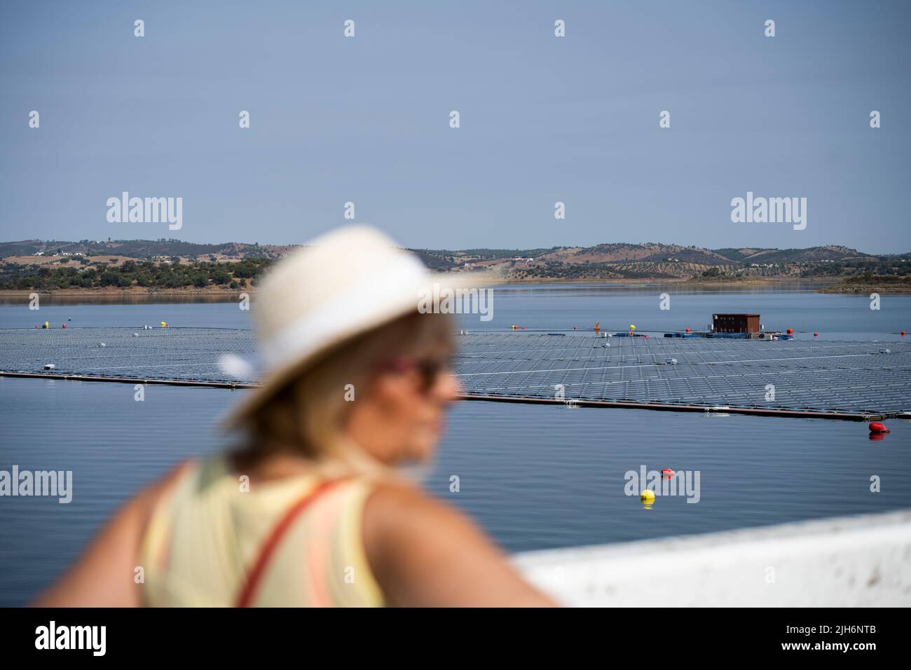 A tourist is seen overlooking the floating solar power plant in Alqueva ...