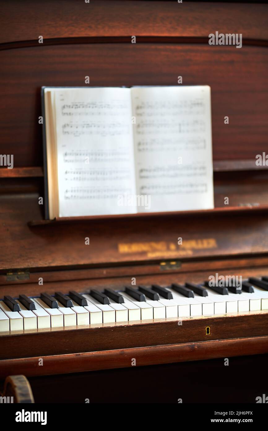 Old vintage piano with musical notes at a classical music festival. An ...