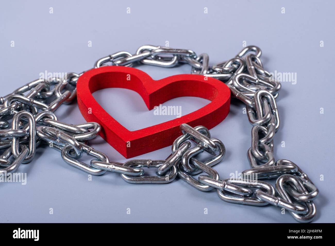 Heart shape with metallic chain around it in a blue background Stock ...