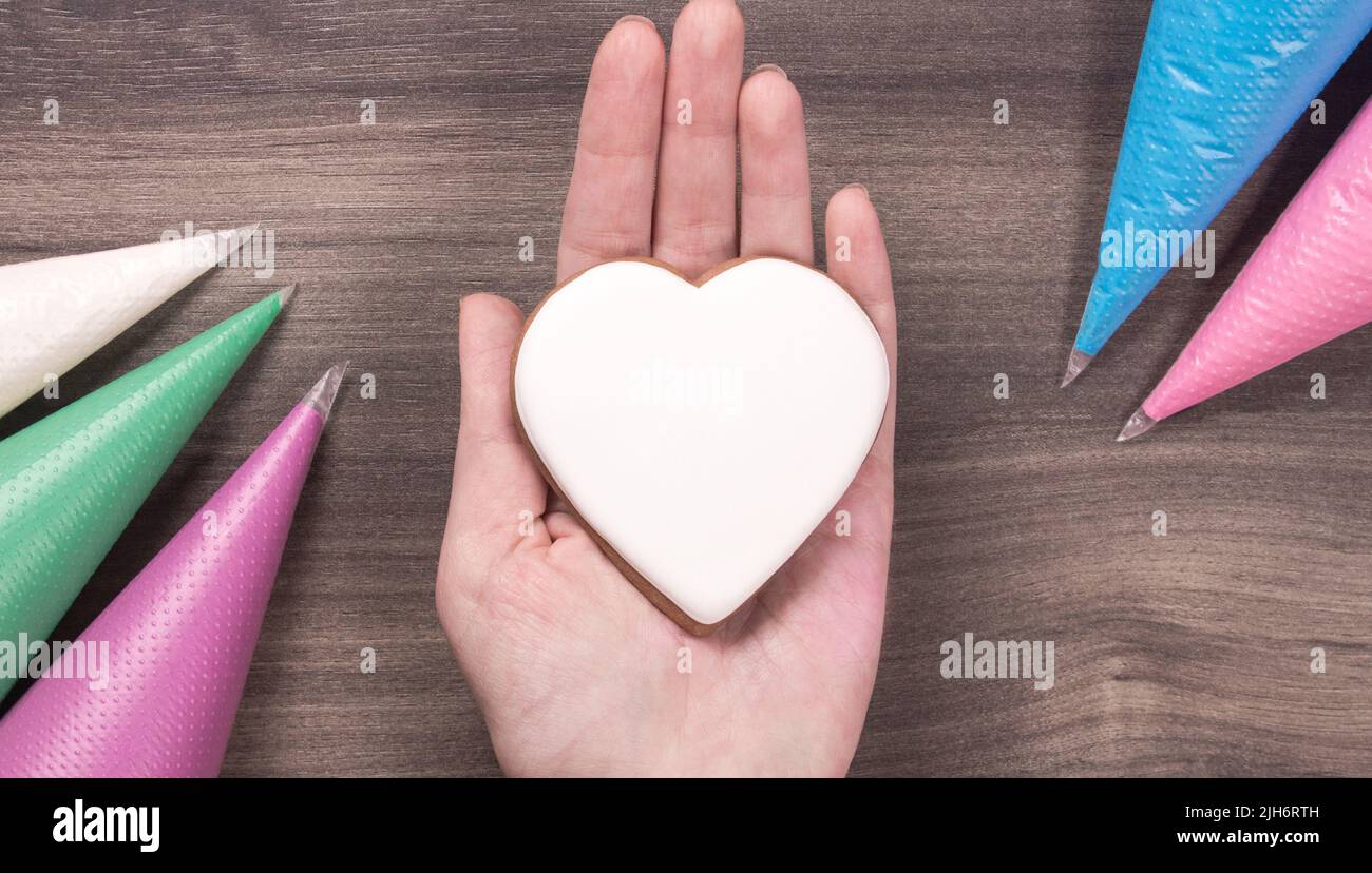 Hand holding white heart shape cookie for Mothers day, Womans day or ...