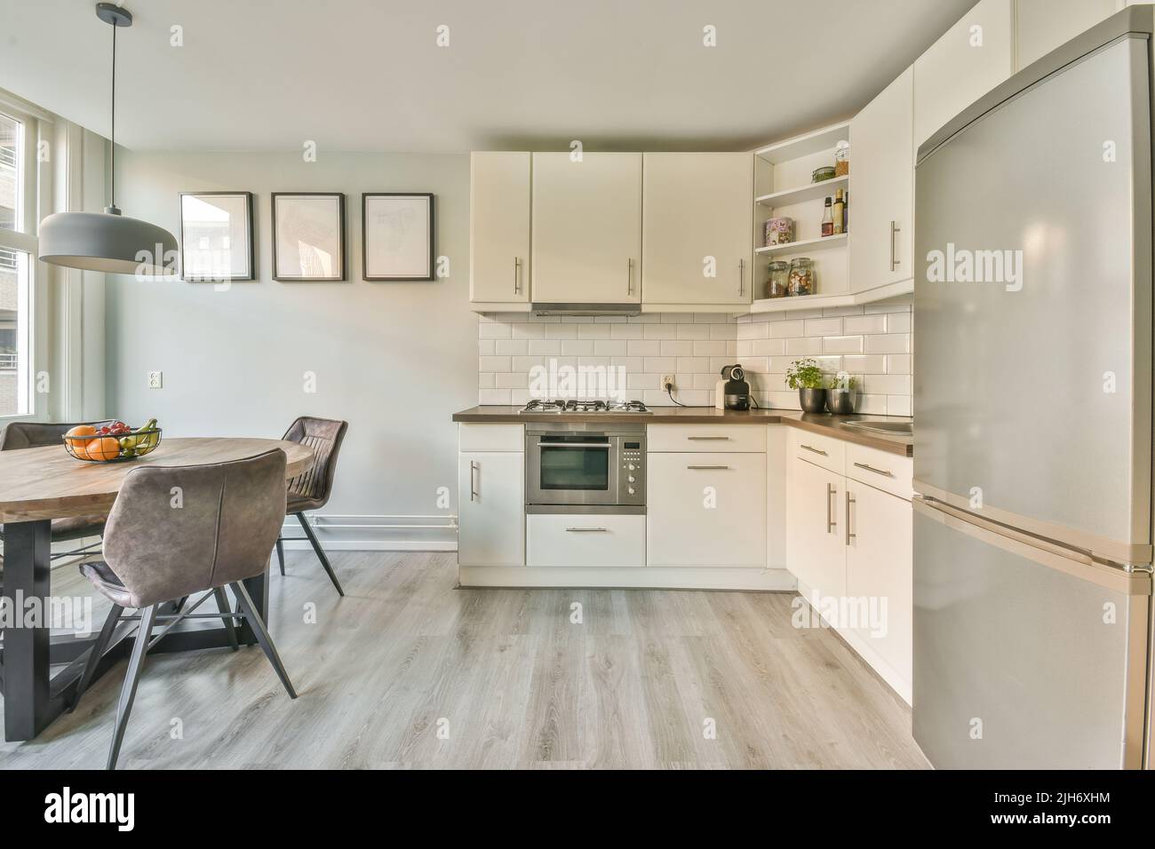 Studio apartment with white walls and open plan kitchen and dining zone ...