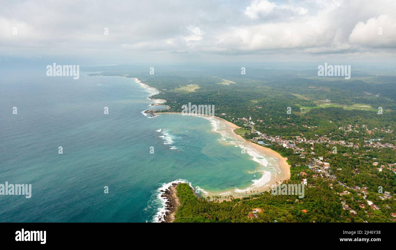 The coast with a beach and hotels among palm trees. Dickwella Beach ...