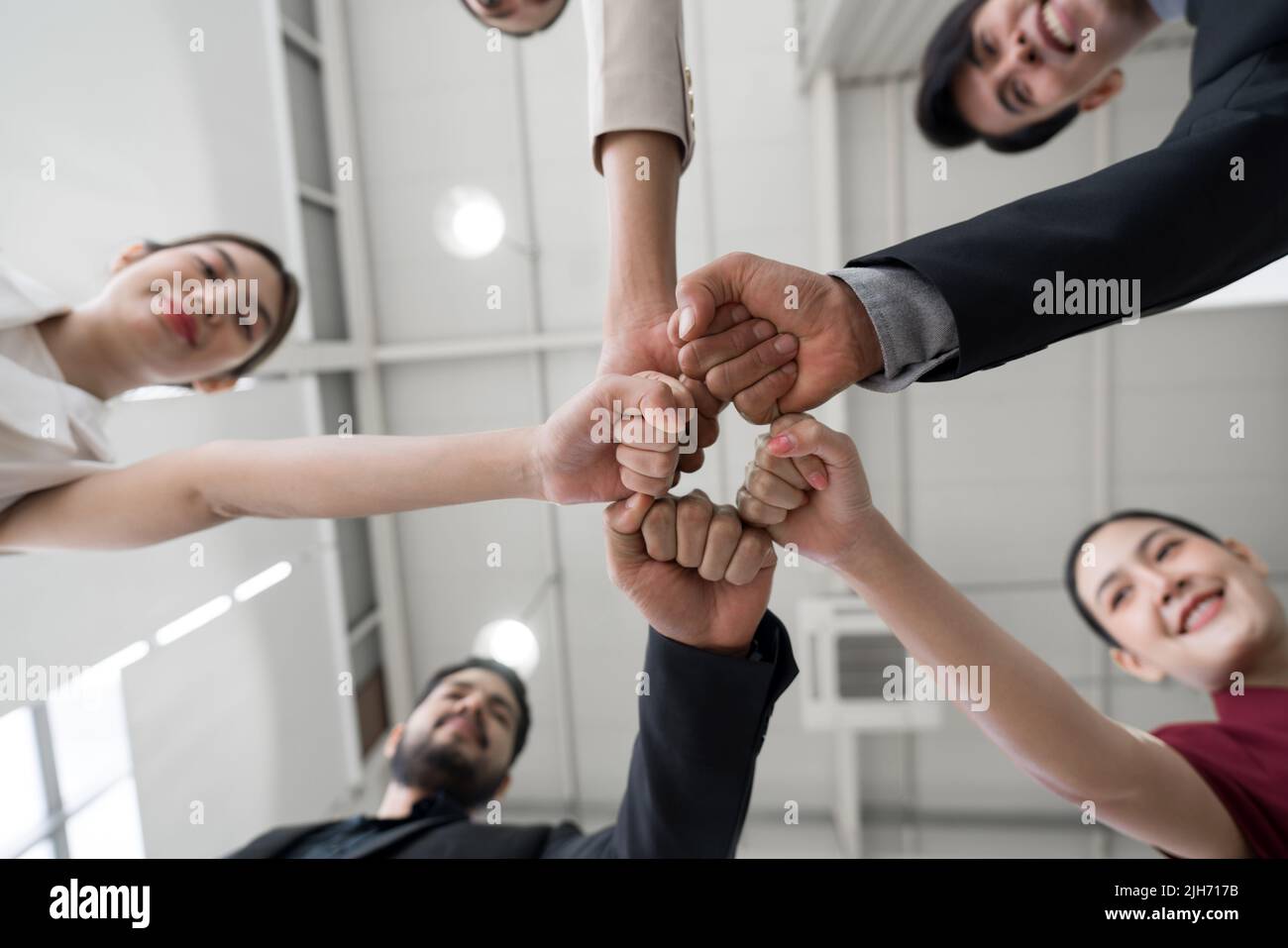 Team building concept. Coworkers standing in circle bumping fist ...